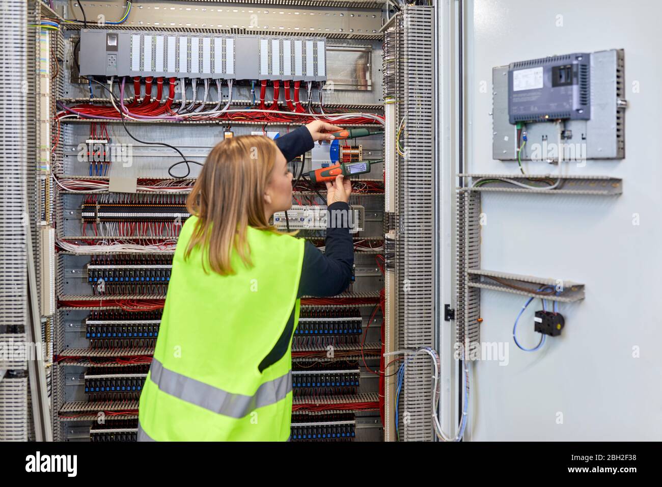 Female electrician working with voltmeter at fuse box Stock Photo - Alamy