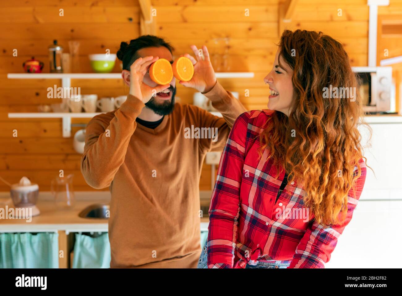 Playful young couple having fun in a wooden cabin Stock Photo - Alamy
