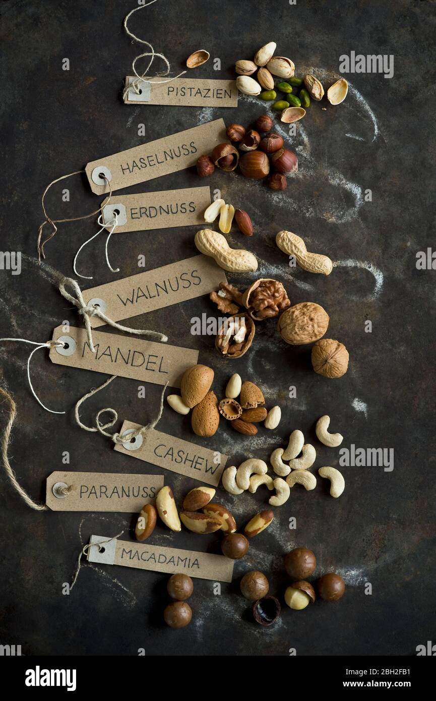 Collection of various nuts with name tags lying on rustic baking sheet ...