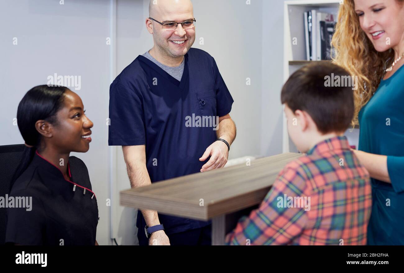 People at reception desk of a dental practice Stock Photo - Alamy