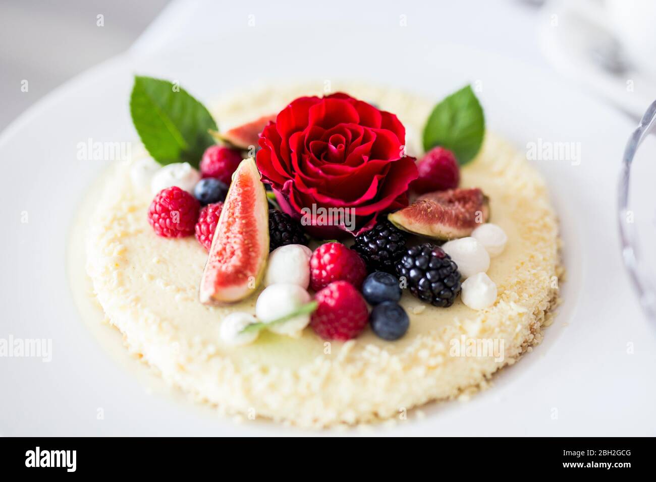 Raspberry cake decorated with blooming rose Stock Photo - Alamy