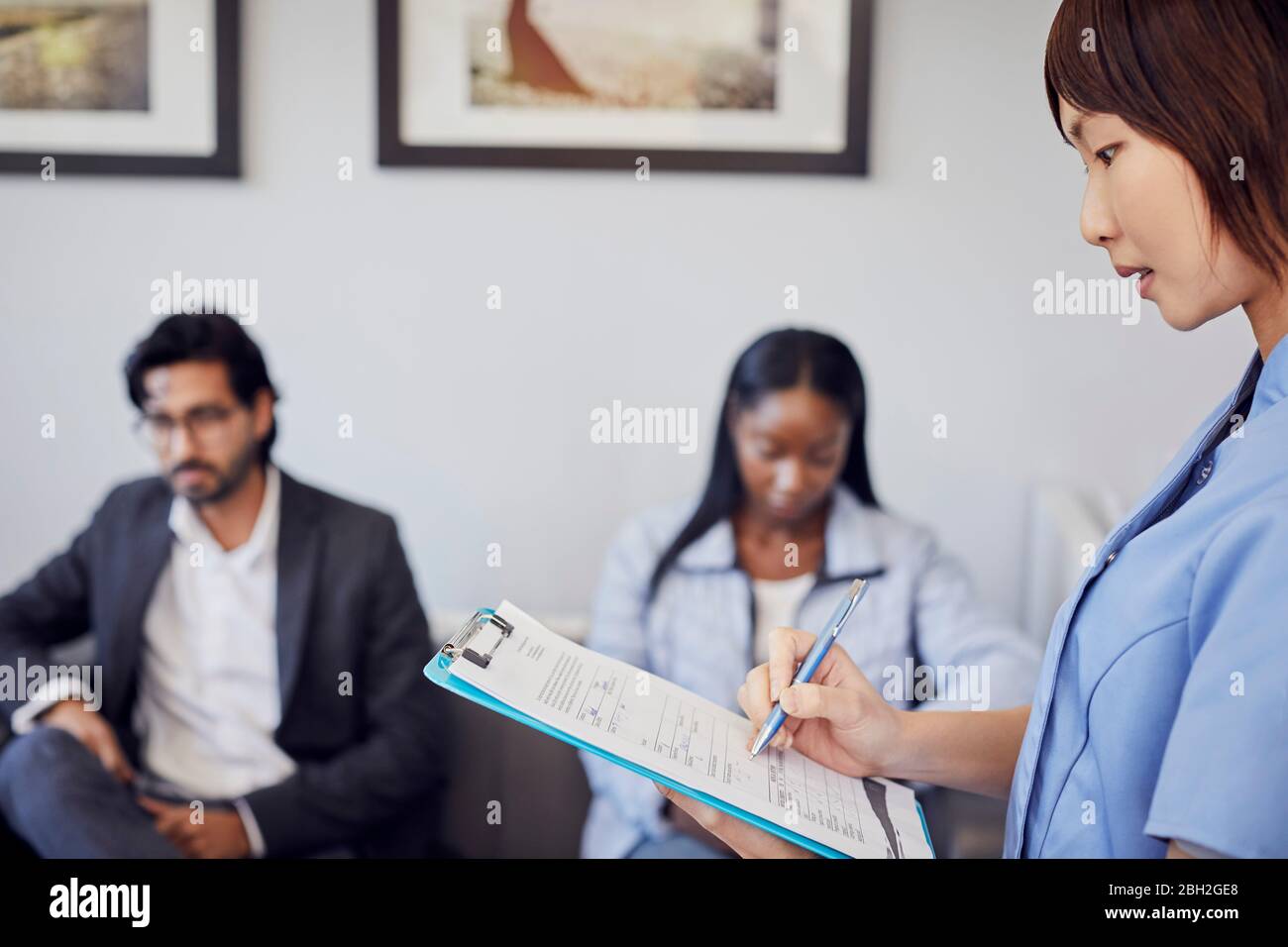 Receptionist checking form in waiting room of a dental practice Stock ...
