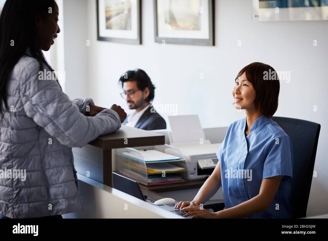 Patient at reception desk of a dental practice Stock Photo - Alamy