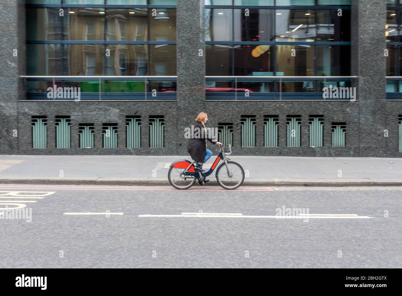 Woman riding bicycle in the city, London, UK Stock Photo - Alamy