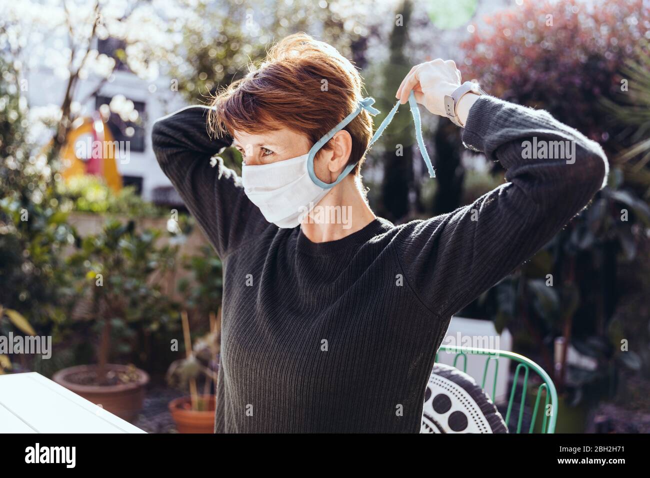 Woman putting on face mask hi-res stock photography and images - Alamy
