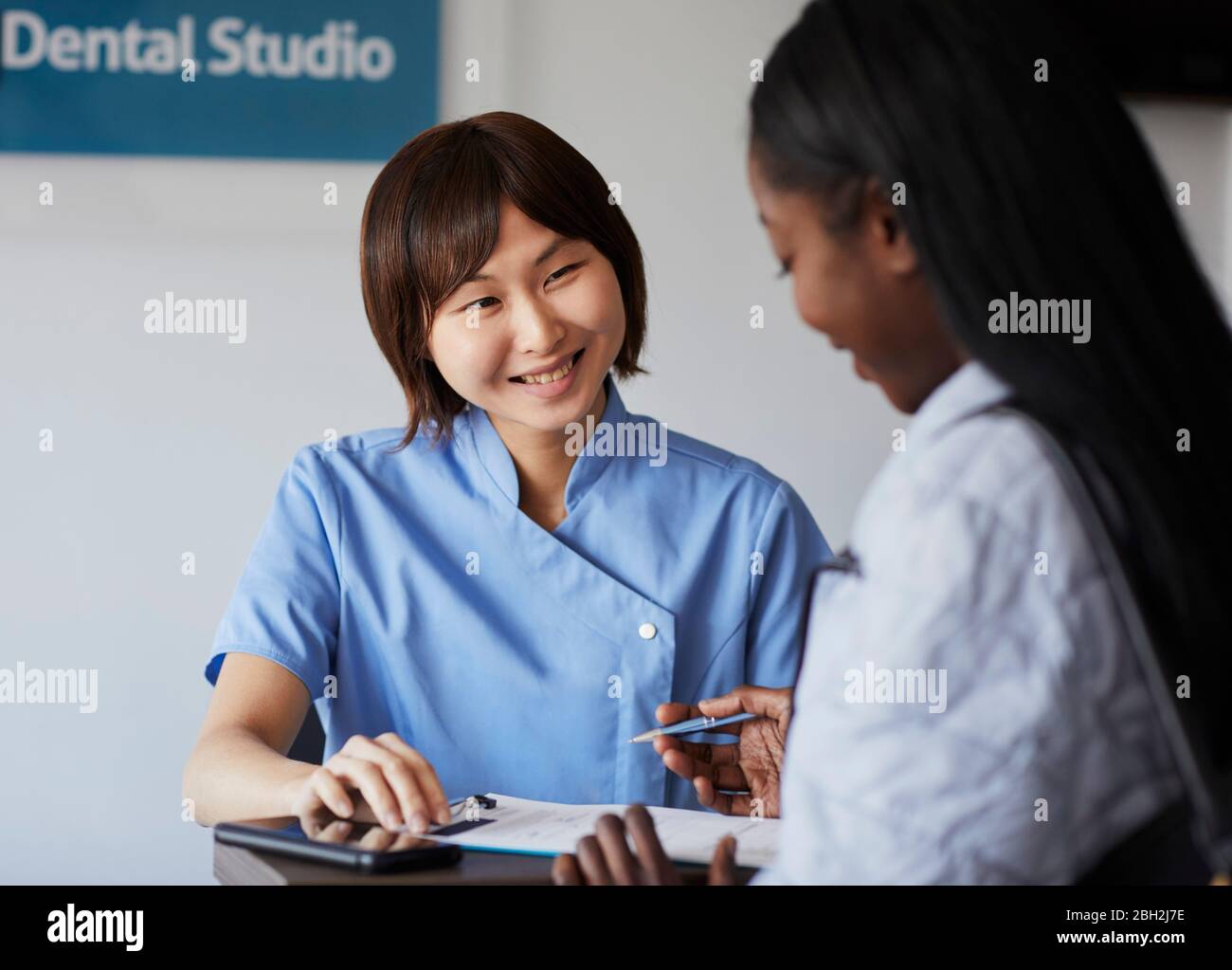 Patient at reception desk of a dental practice Stock Photo - Alamy