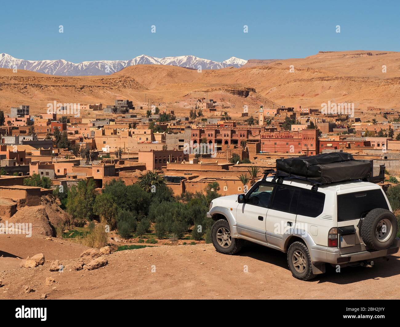 Morocco, Ait Benhaddou, 4x4 car on hill overlooking ancient fortified ...
