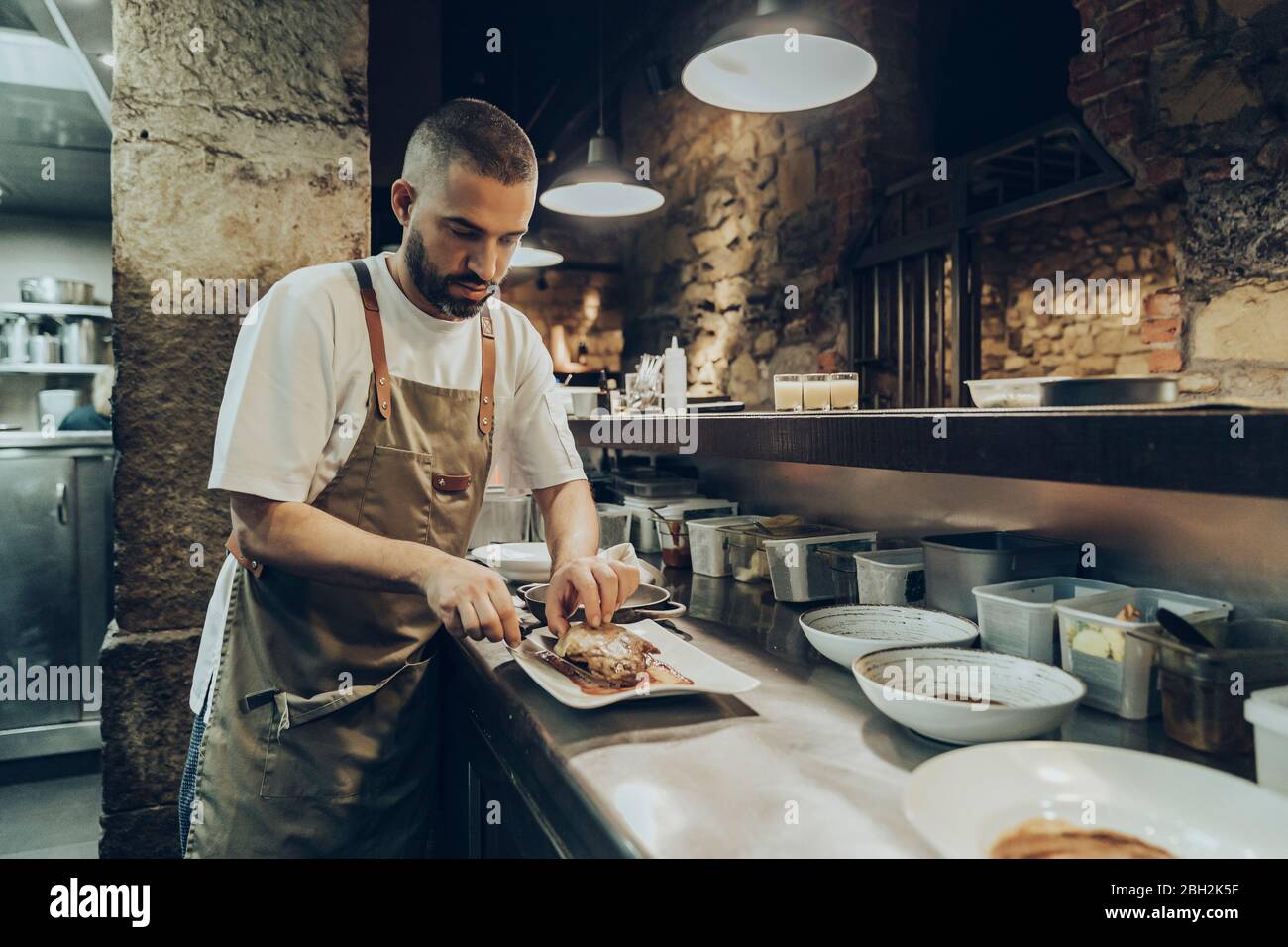 Chef arranging food on plate before serving in restaurant Stock Photo ...