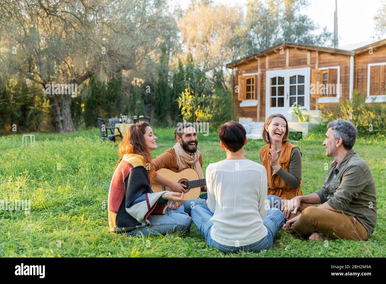 Friends playing music enjoying a getaway in the countryside Stock Photo ...
