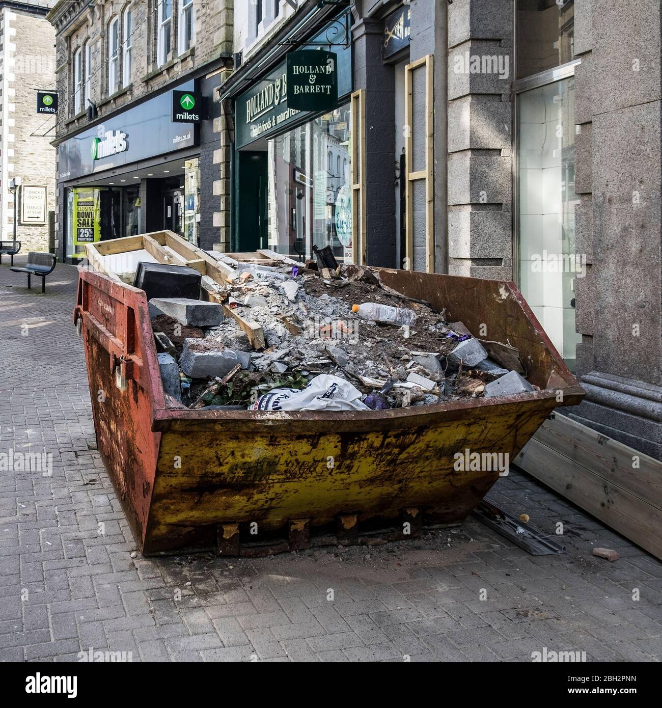 A building skip full of rubble in a street in Newquay Town centre in ...