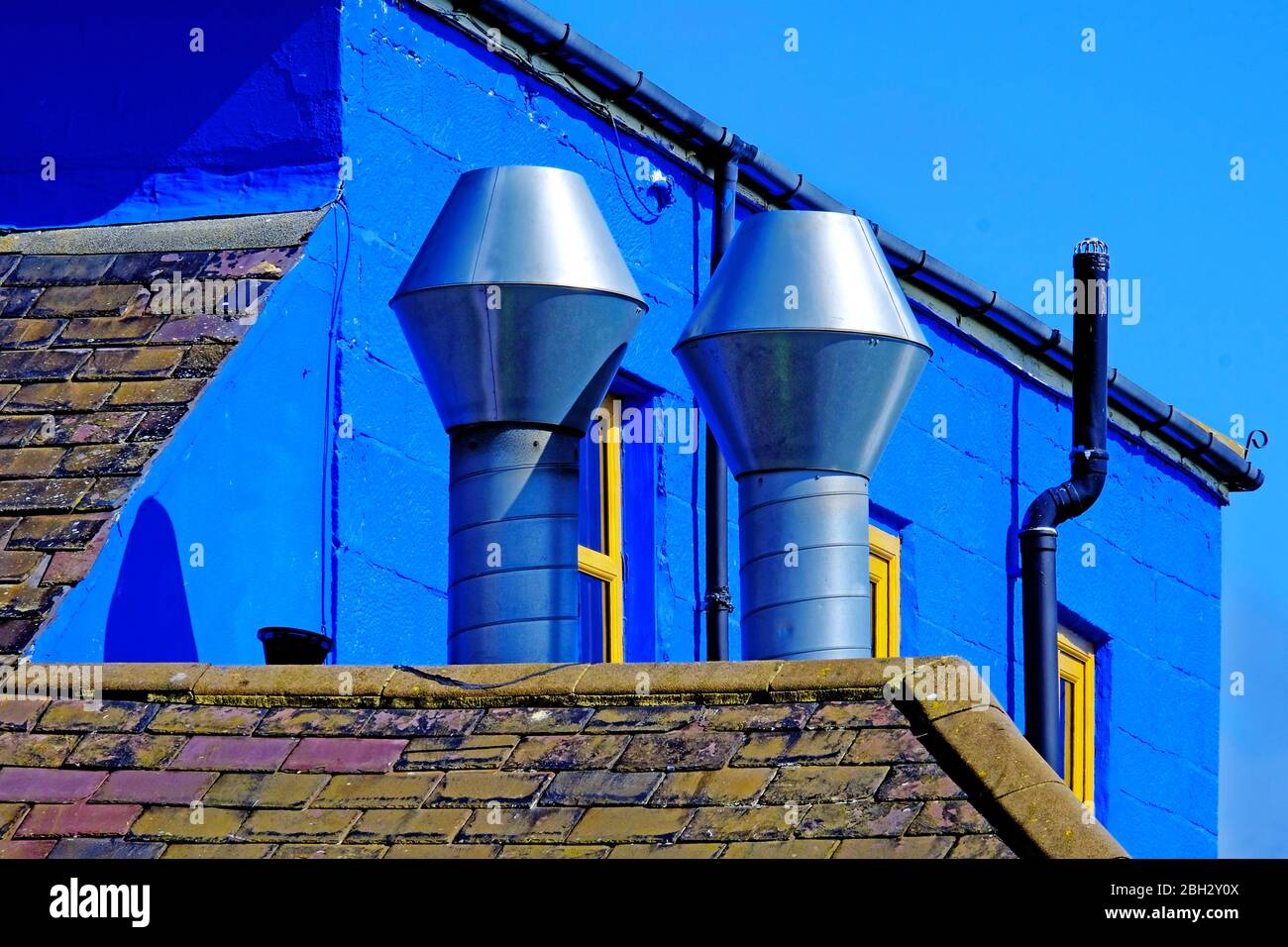 2 ventilation ducts among rooftop slates with blue sky Stock Photo - Alamy