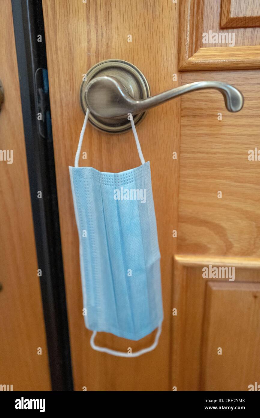 Close-up of blue surgical mask hanging on a doorknob, April 5, 2020 ...