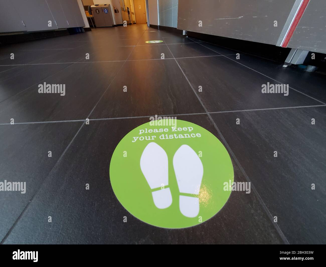 Social distancing marker on floor with text reading Keep Your Distance ...