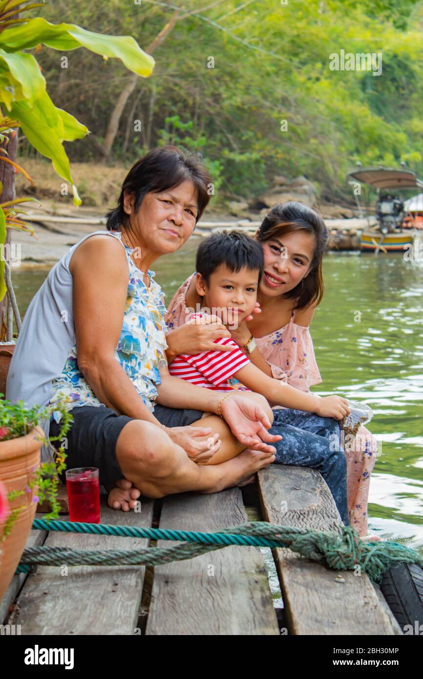 Mother and son sit to feed the fish Stock Photo - Alamy