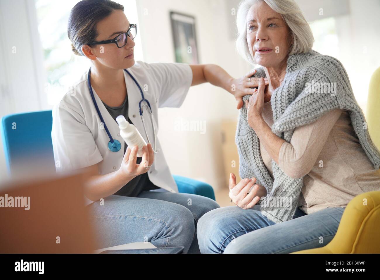 Doctor demonstrating topical application on senior woman Stock Photo ...