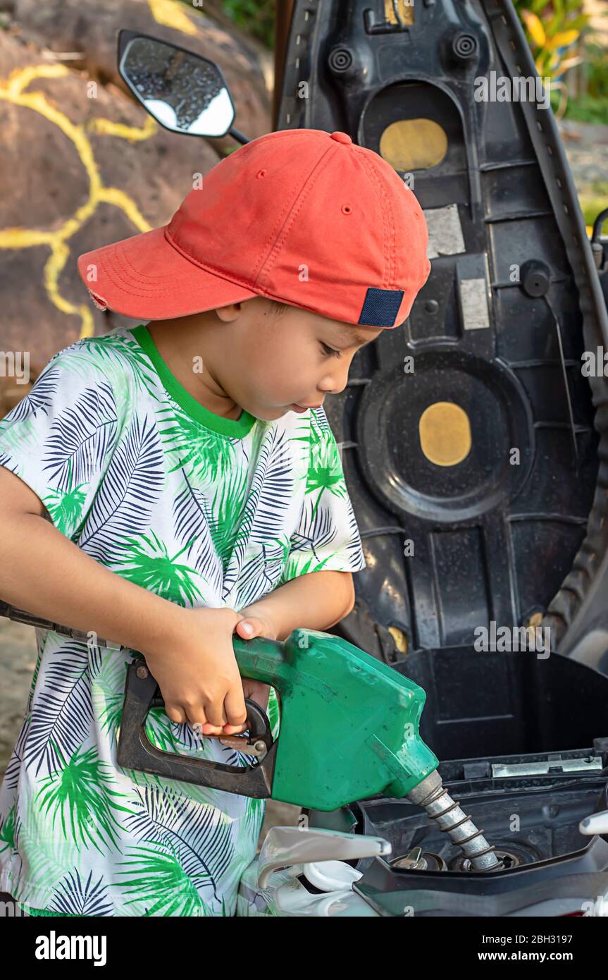Asian boy filling up fuel into the motorbike Stock Photo - Alamy