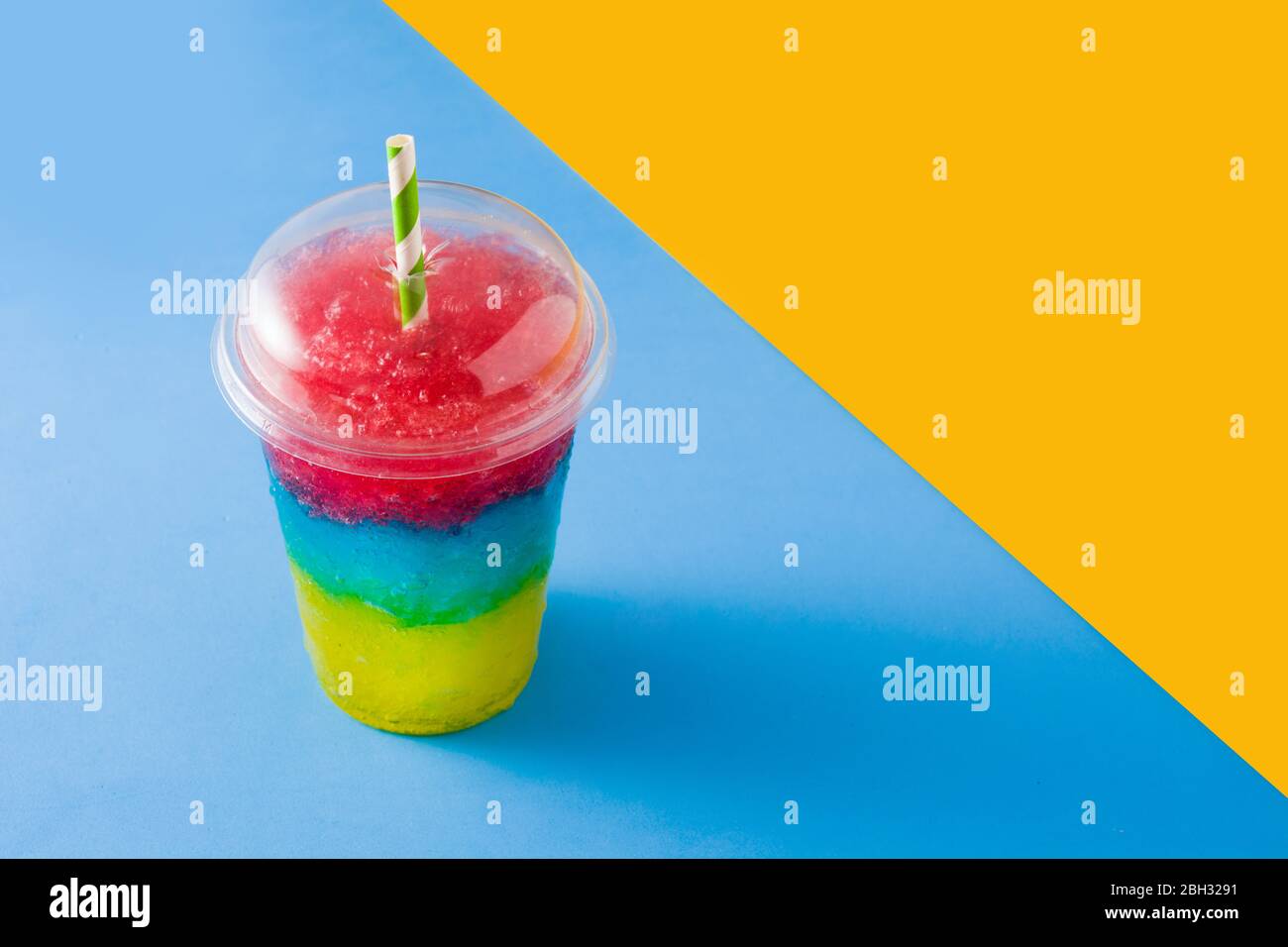Colorful slushie of differents flavors on yellow and blue background ...