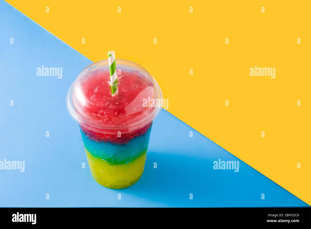 Colorful slushie of differents flavors on yellow and blue background ...