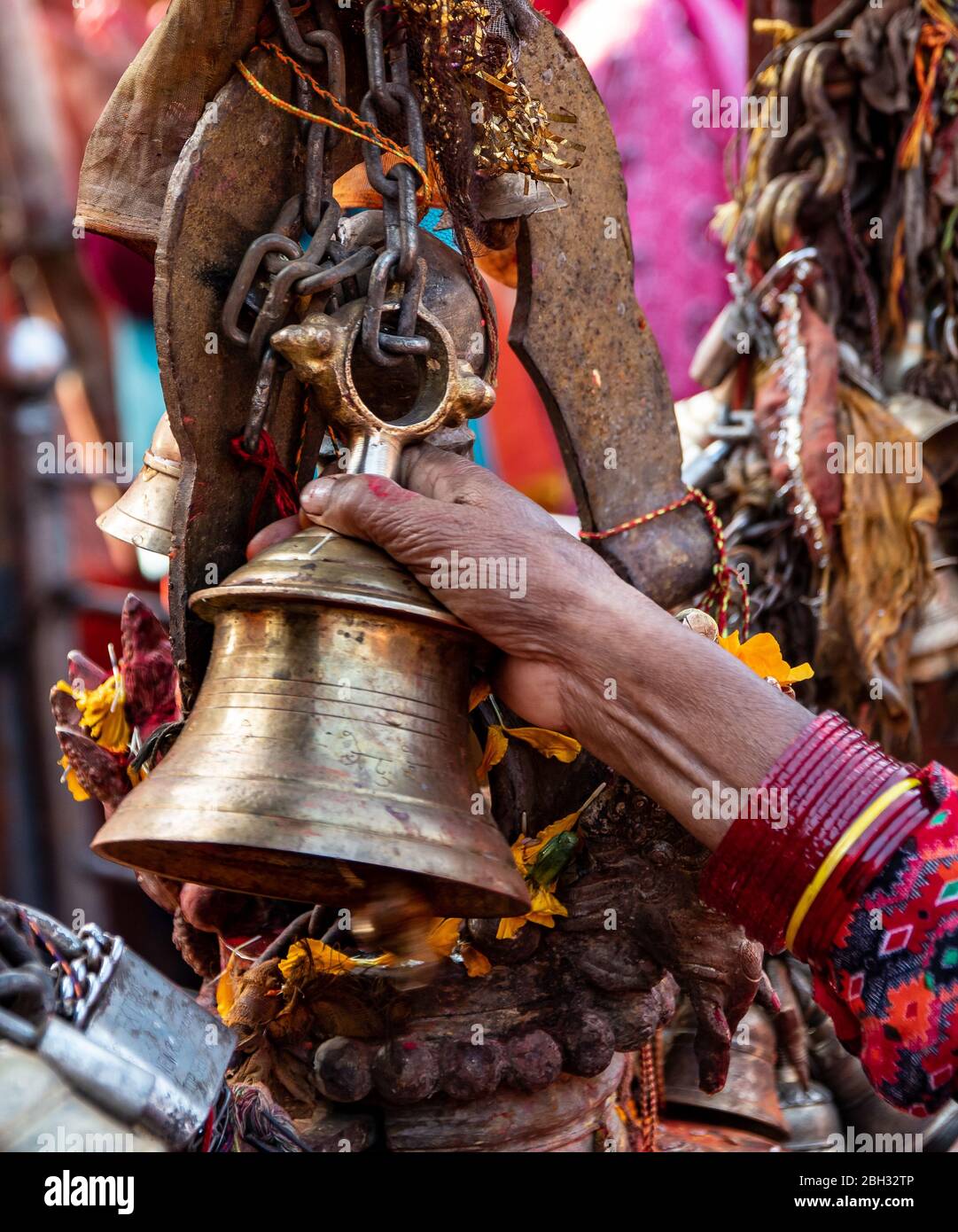 Hand of a nepali woman ringing a sacred bell in a Kathmandu temple ...