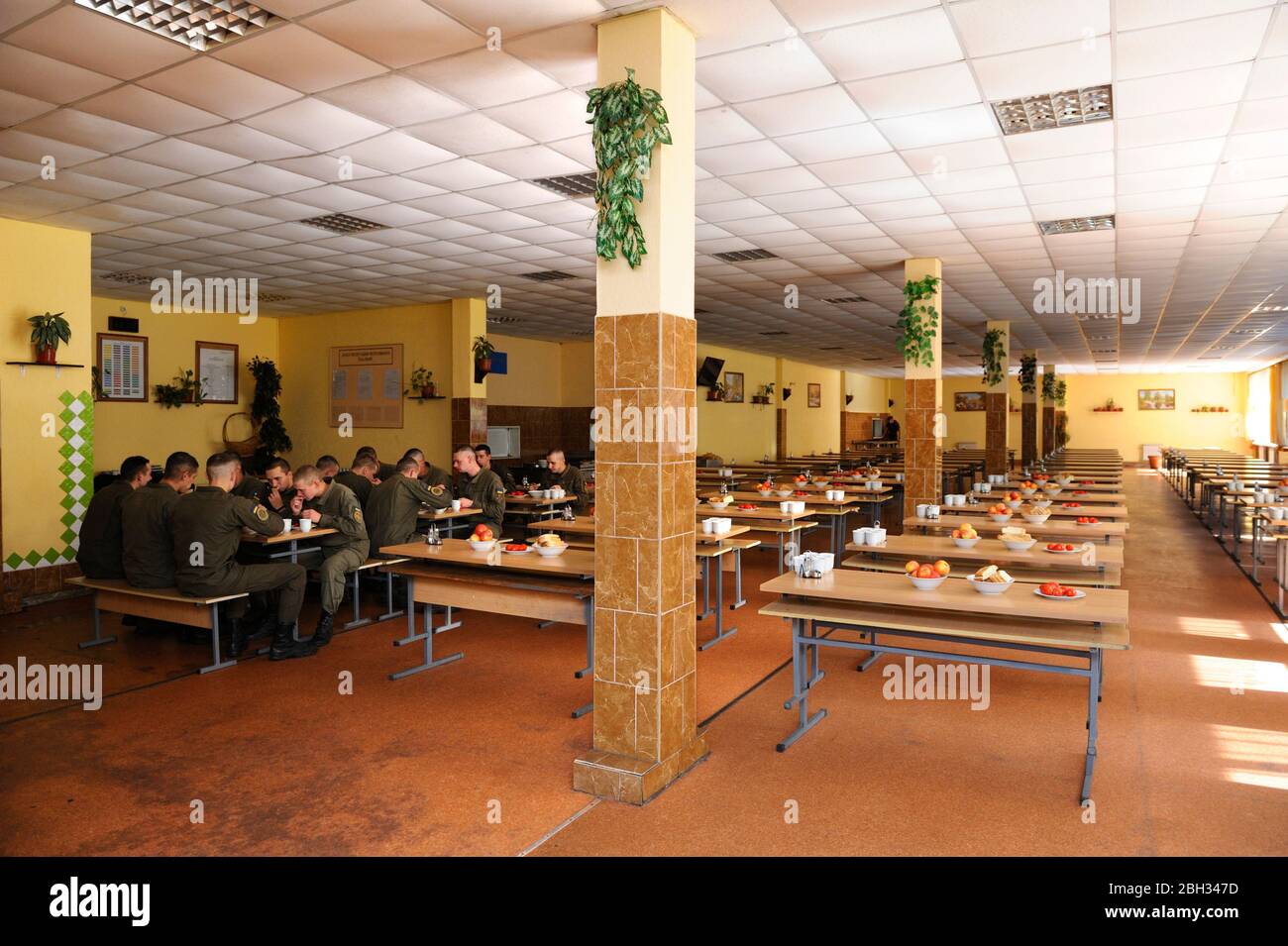 At a mess hall: soldiers sitting at set-out tables and eating. Novo ...