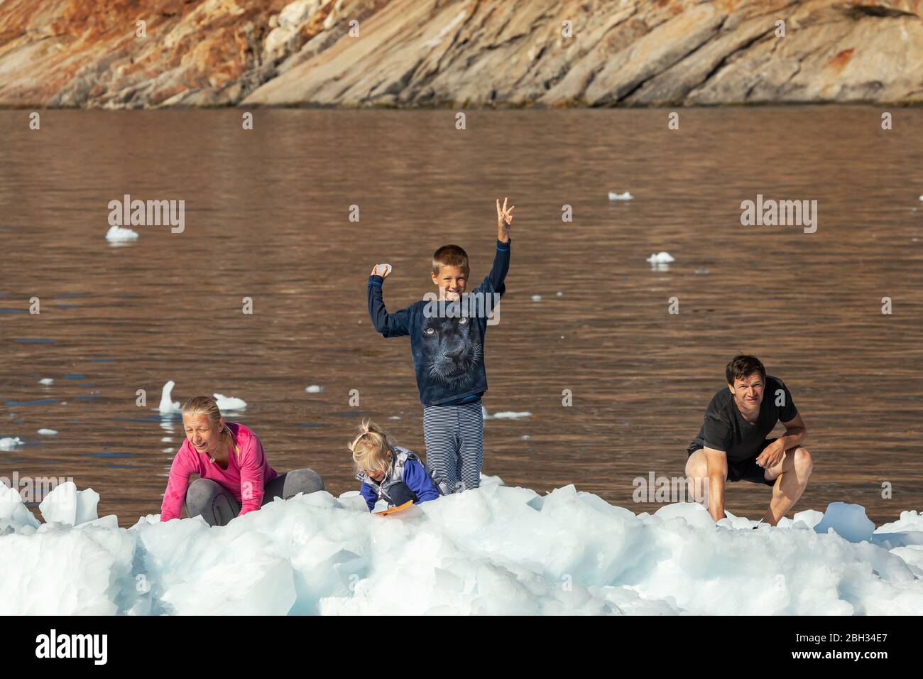 People playing on an iceberg in Greenland Stock Photo - Alamy