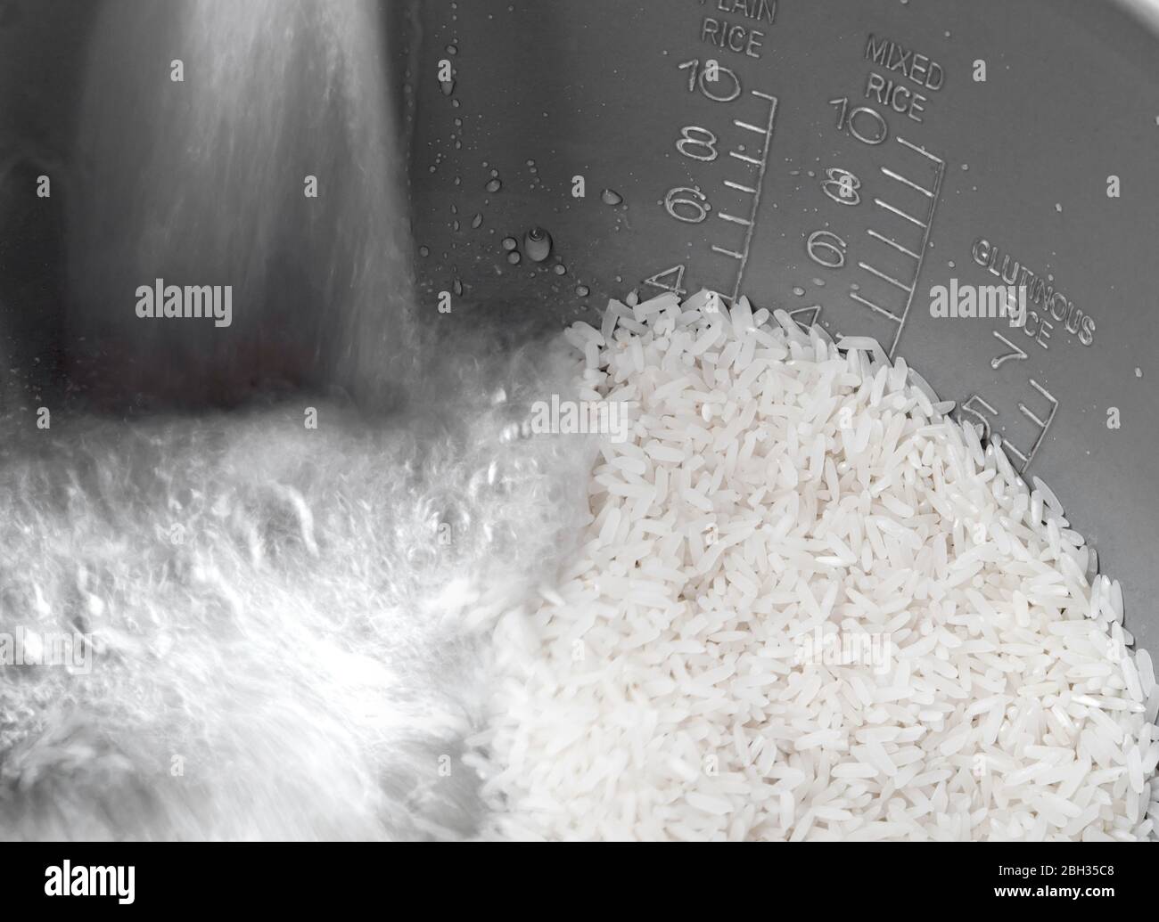 Rice prepared for cooking in an electric rice cooker Stock Photo - Alamy