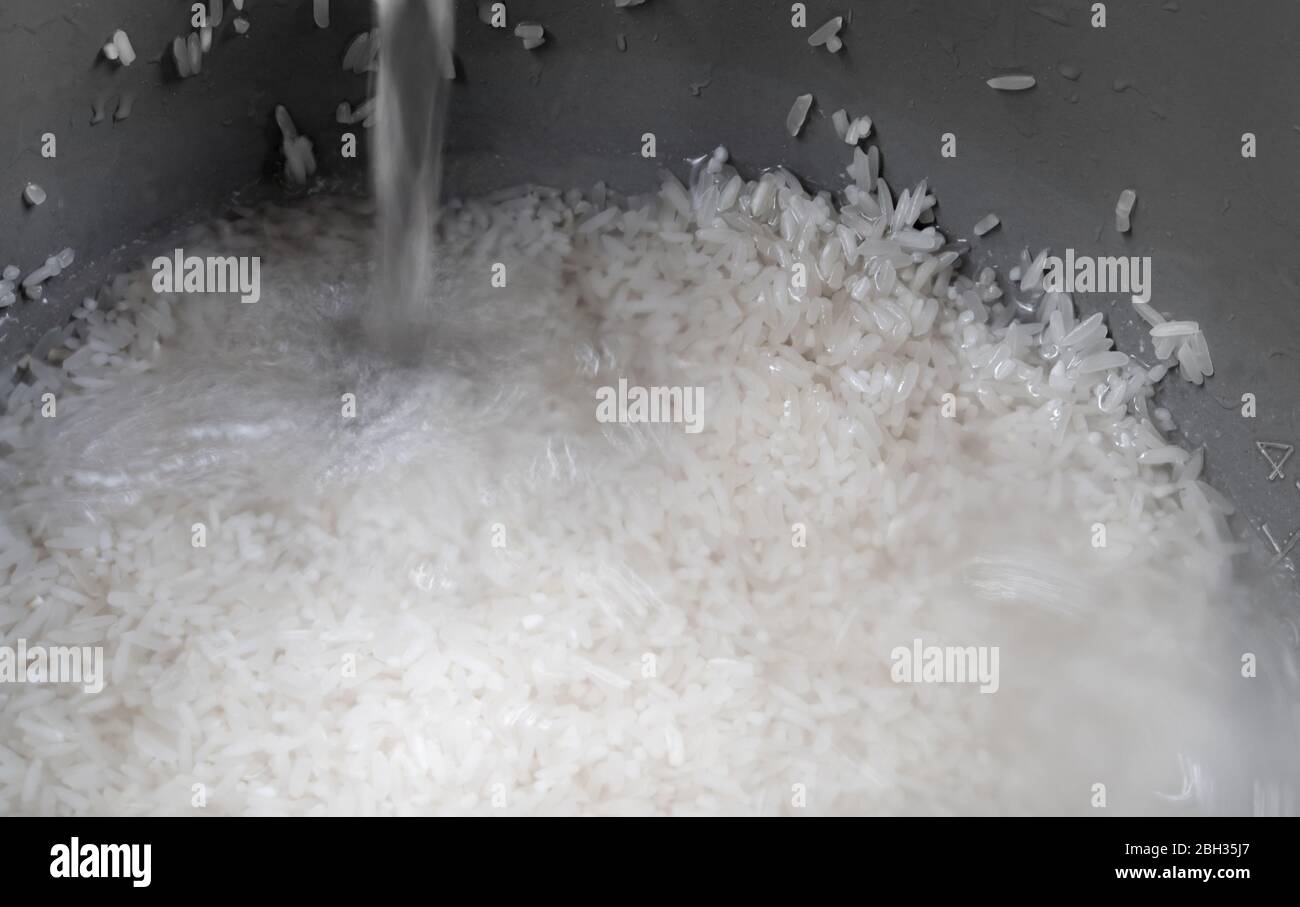 Rice prepared for cooking in an electric rice cooker Stock Photo - Alamy