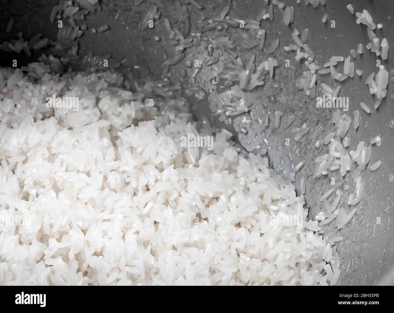 Rice prepared for cooking in an electric rice cooker Stock Photo - Alamy