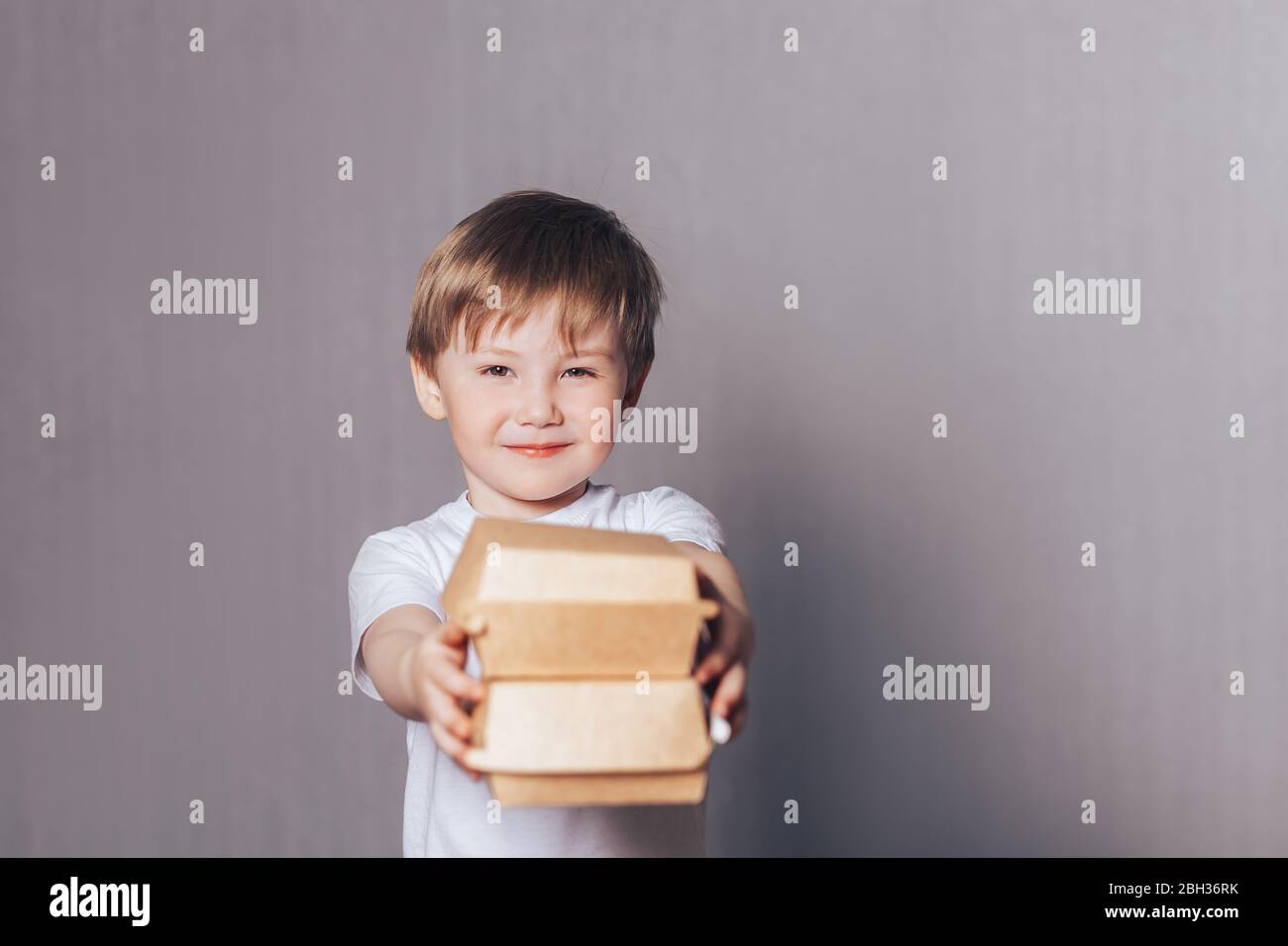 Beautiful little boy holding boxes in hands Stock Photo - Alamy