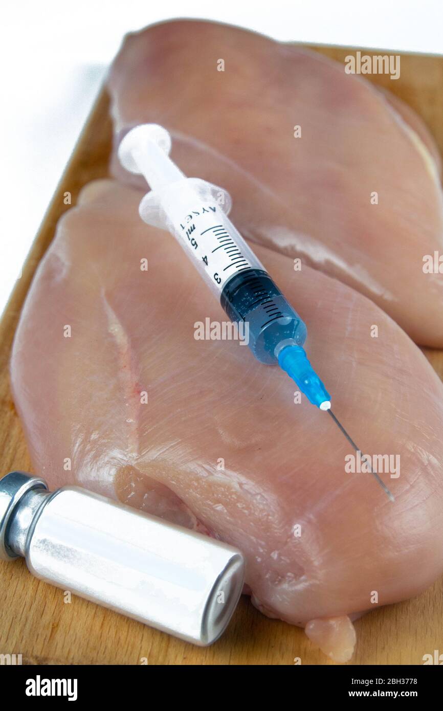 Syringe with liquid being injected to a piece of meat. Conceptual ...
