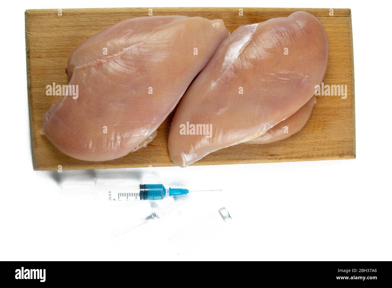 Syringe with liquid being injected to a piece of meat. Conceptual ...