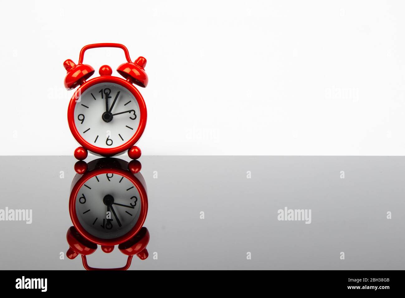 Red retro alarm clock with reflection on a white background Stock Photo ...