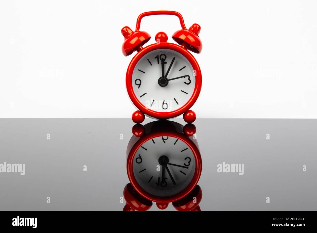 Red retro alarm clock with reflection on a white background Stock Photo ...