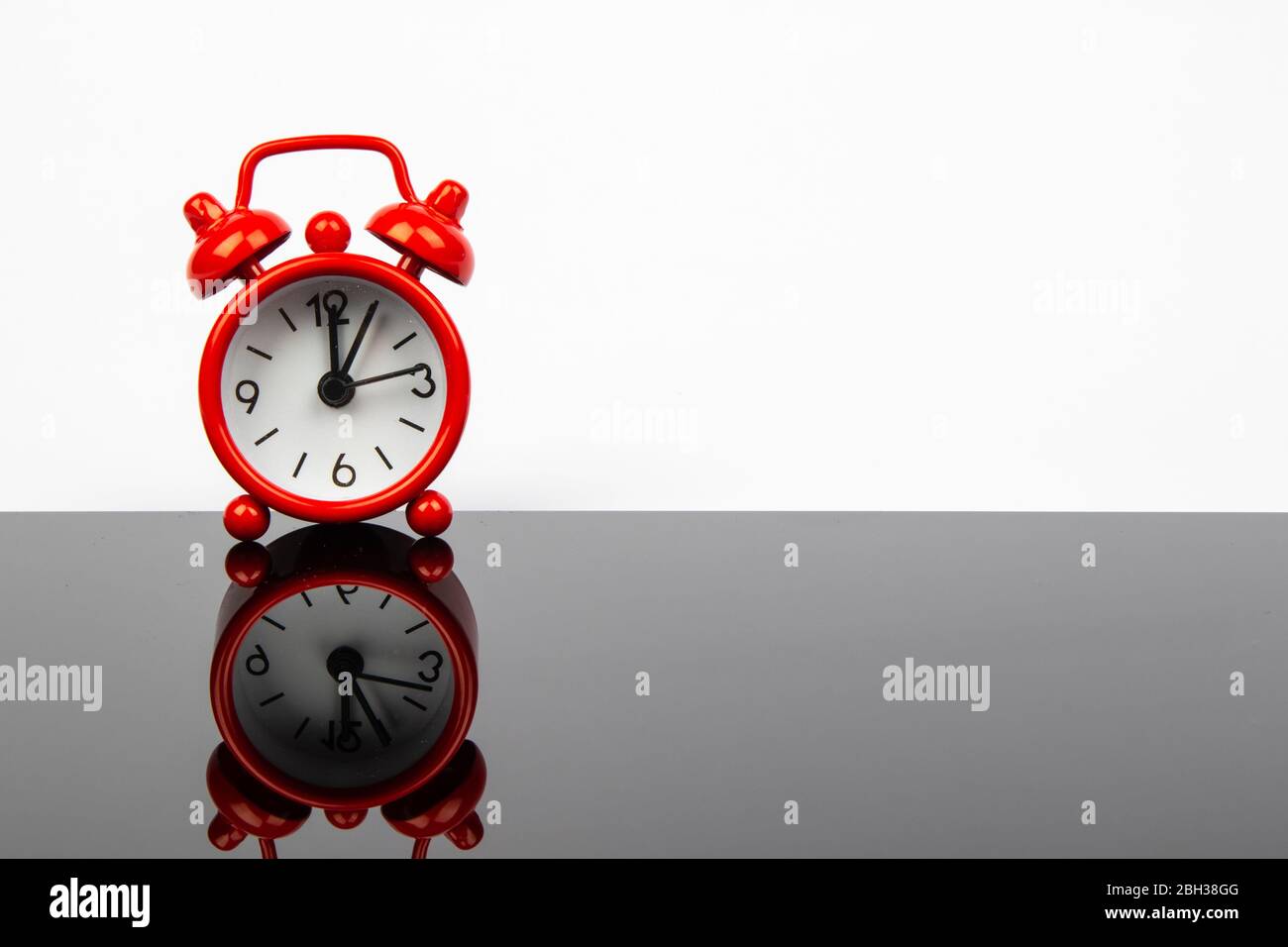 Red retro alarm clock with reflection on a white background Stock Photo ...