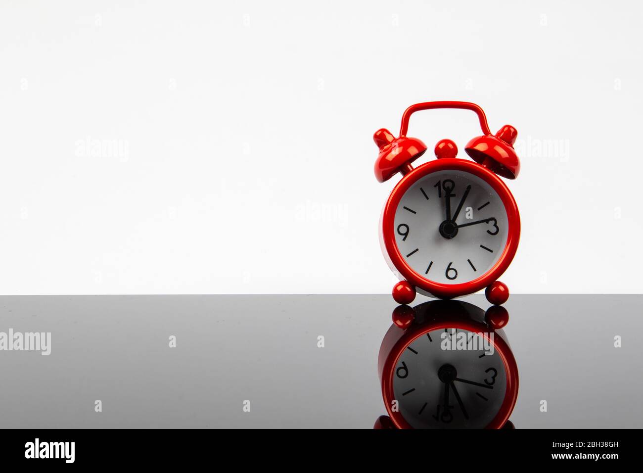Red retro alarm clock with reflection on a white background Stock Photo ...
