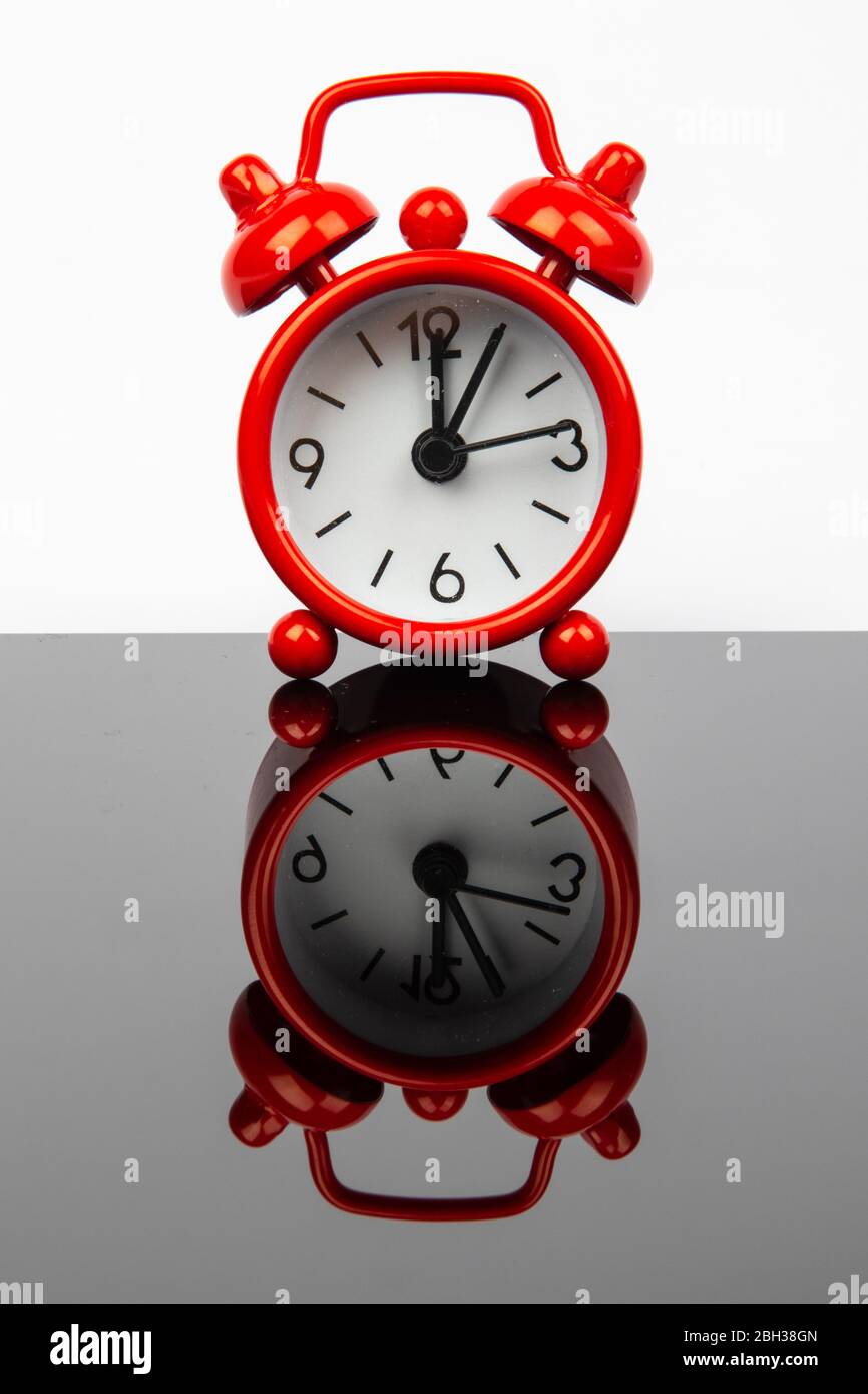 Red retro alarm clock with reflection on a white background Stock Photo ...