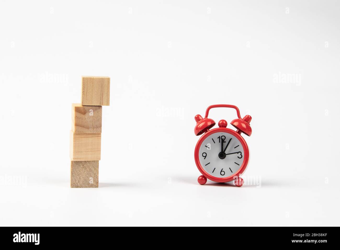 Man hand with wooden block and Red retro alarm clock with reflection on ...