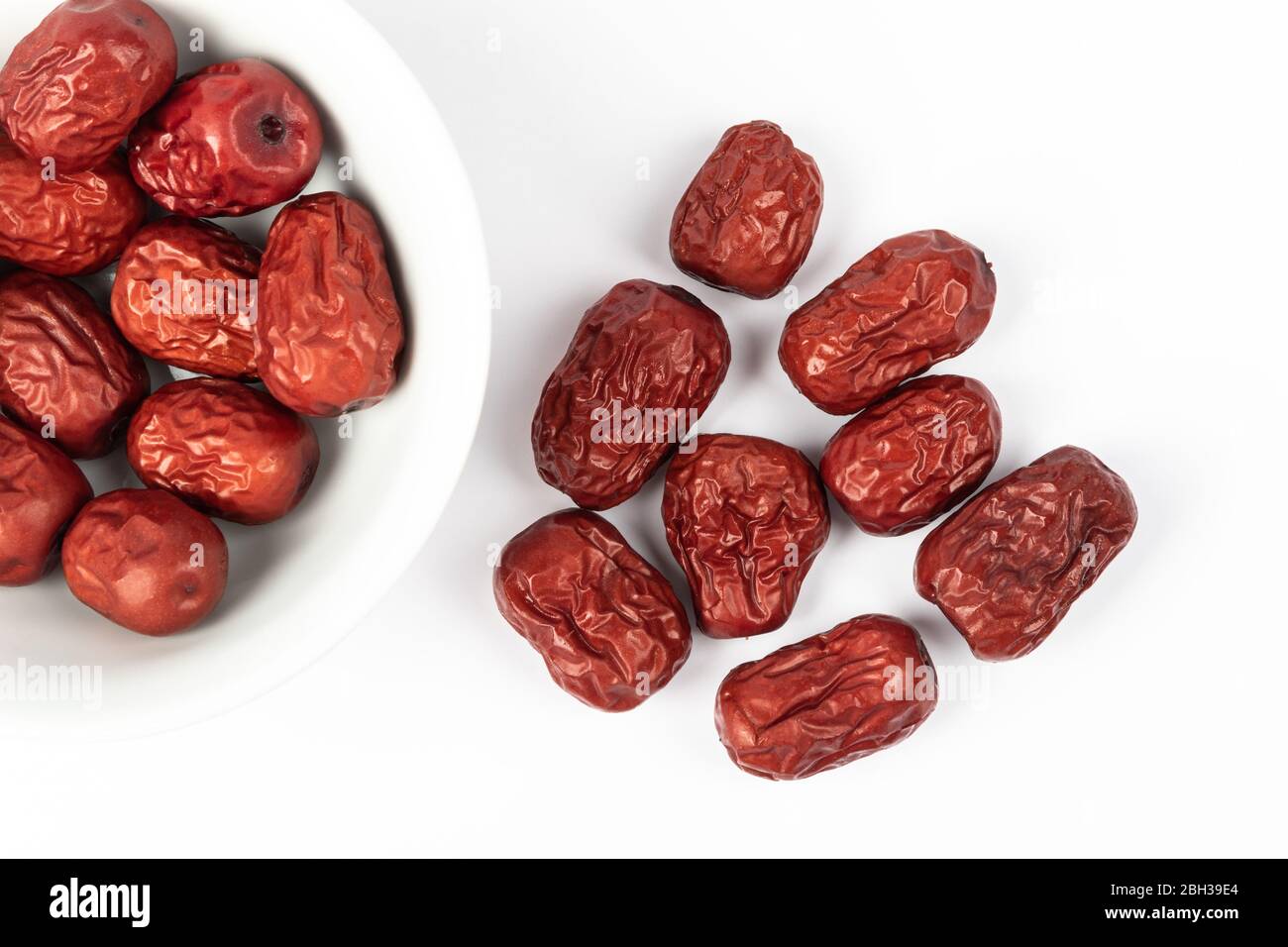 A bowl of Chinese dried red date fruit on white background. Keywords ...