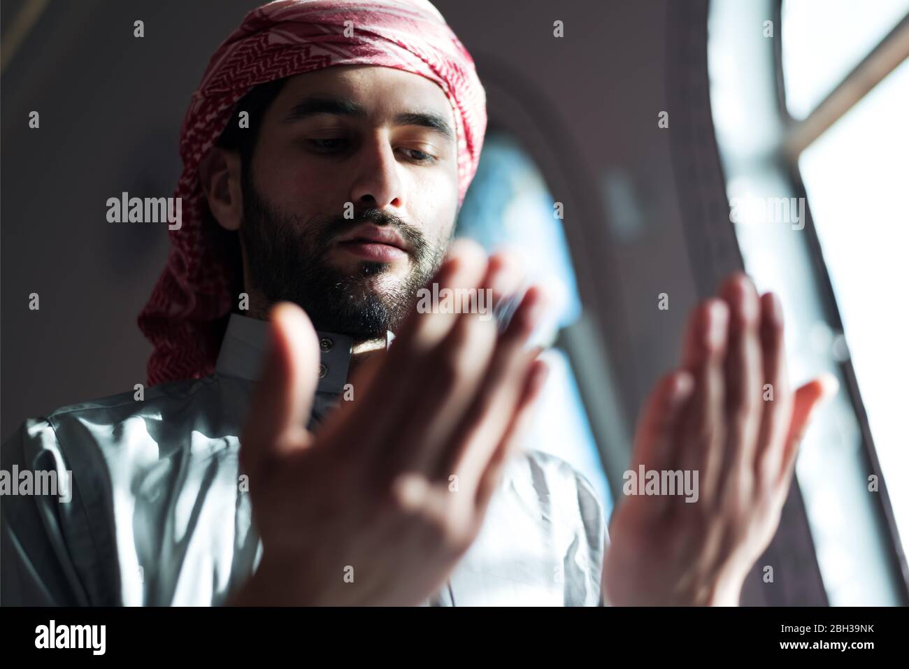 Young Arabic Muslim man praying. Doing a dailly pray inside modern ...