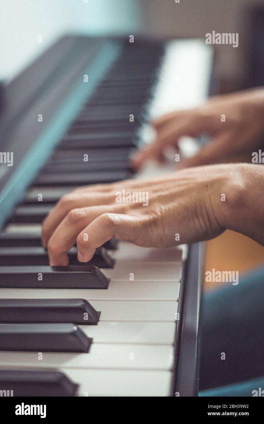 Pretty woman play the piano in home at confined days Stock Photo - Alamy