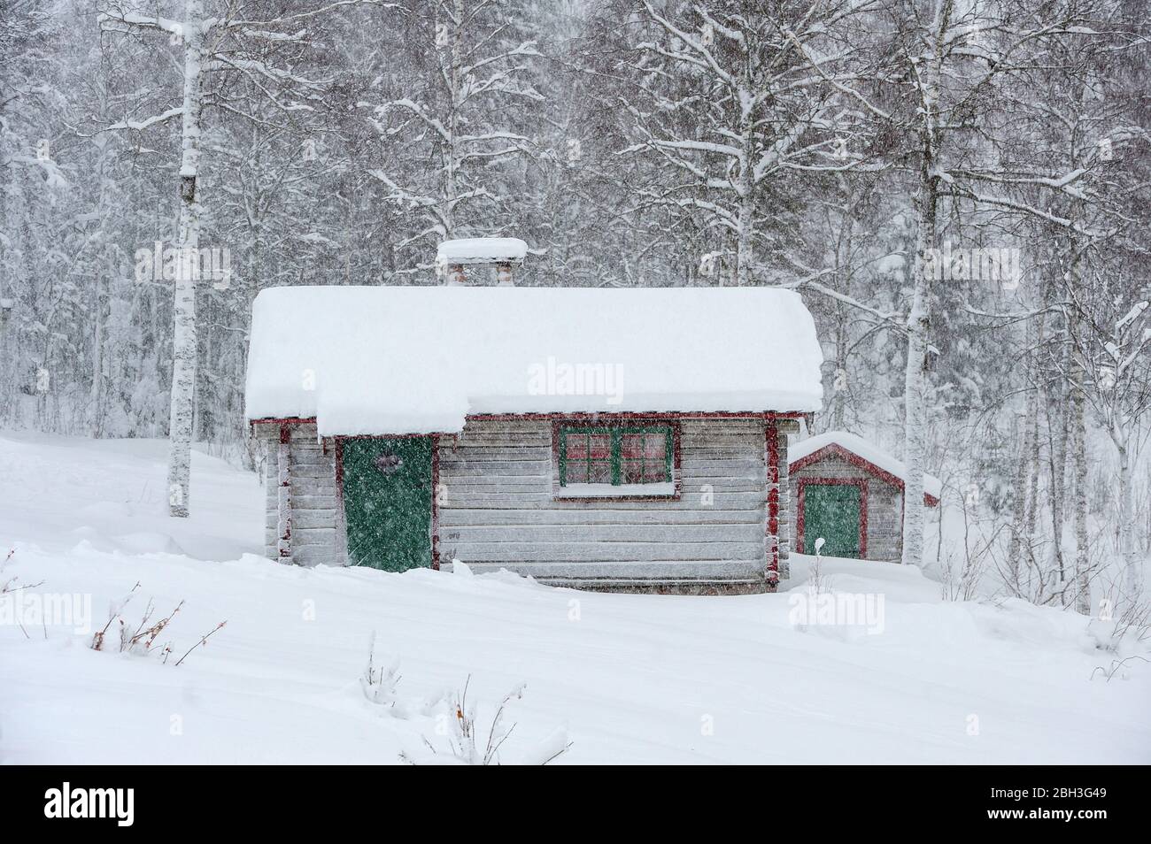 A small log cabin in heavy snowfall in the countryside, Boda kyrkby ...