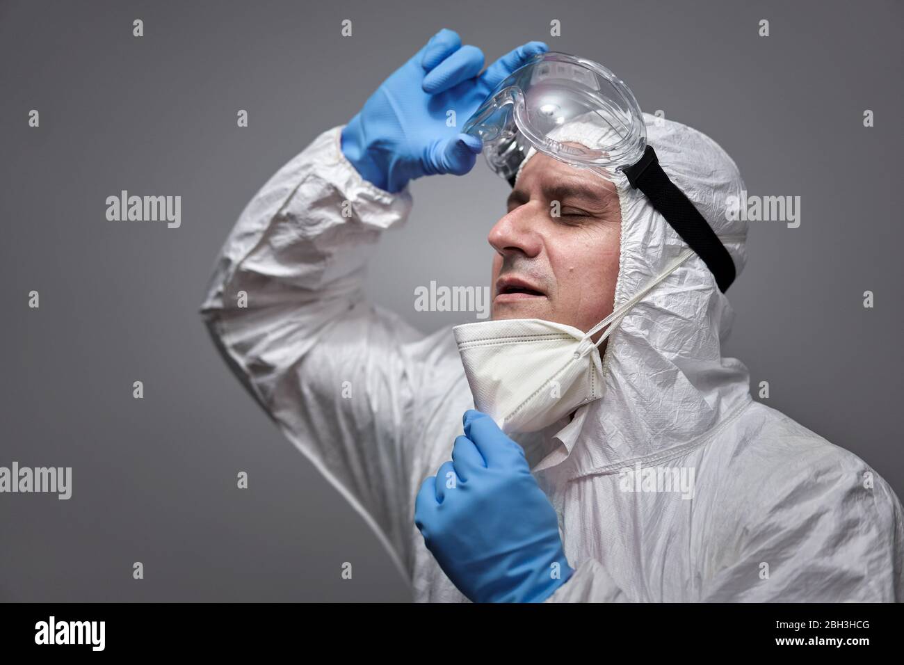 Overwhelmed health worker in overall protection suit Stock Photo - Alamy