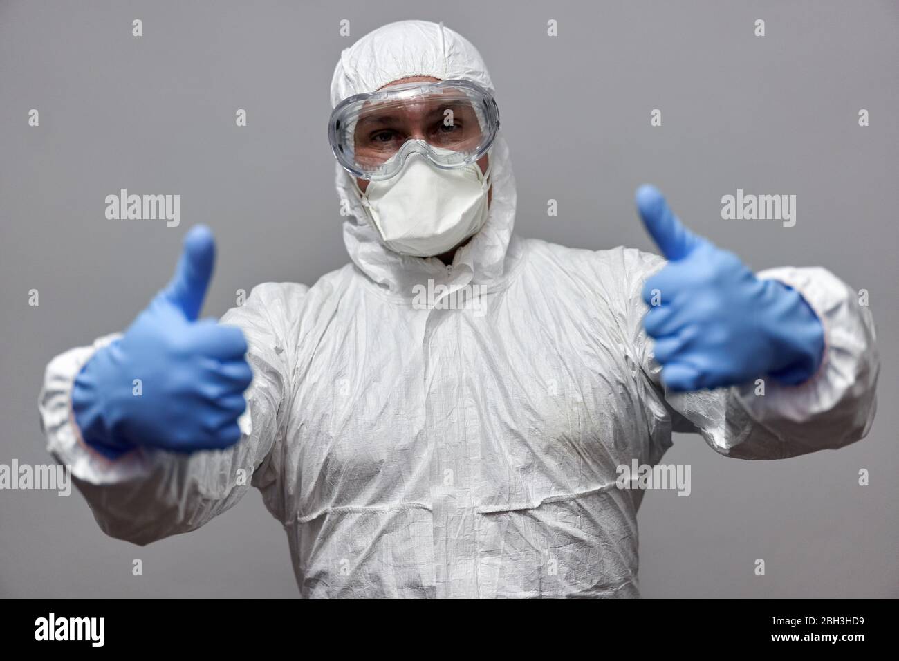 Man in overall protection suit showing thumbs up sign Stock Photo - Alamy