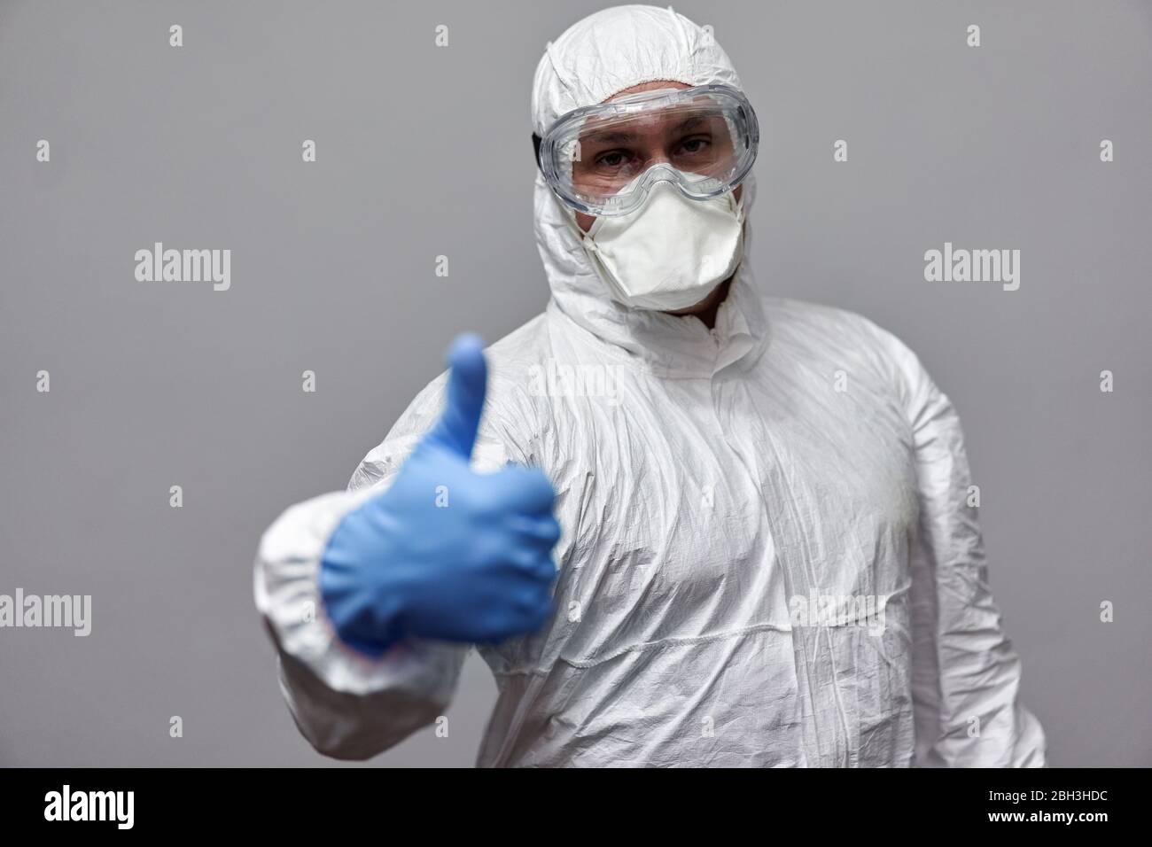 Man in overall protection suit showing thumbs up sign Stock Photo - Alamy