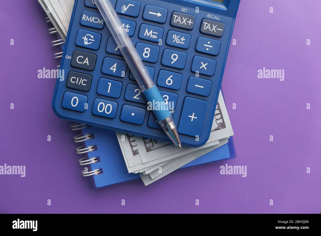 calculator, cash, notepad and pen on purple background Stock Photo - Alamy