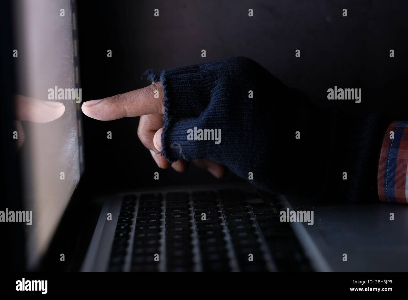 hacker hand pointing finger on laptop screen Stock Photo - Alamy