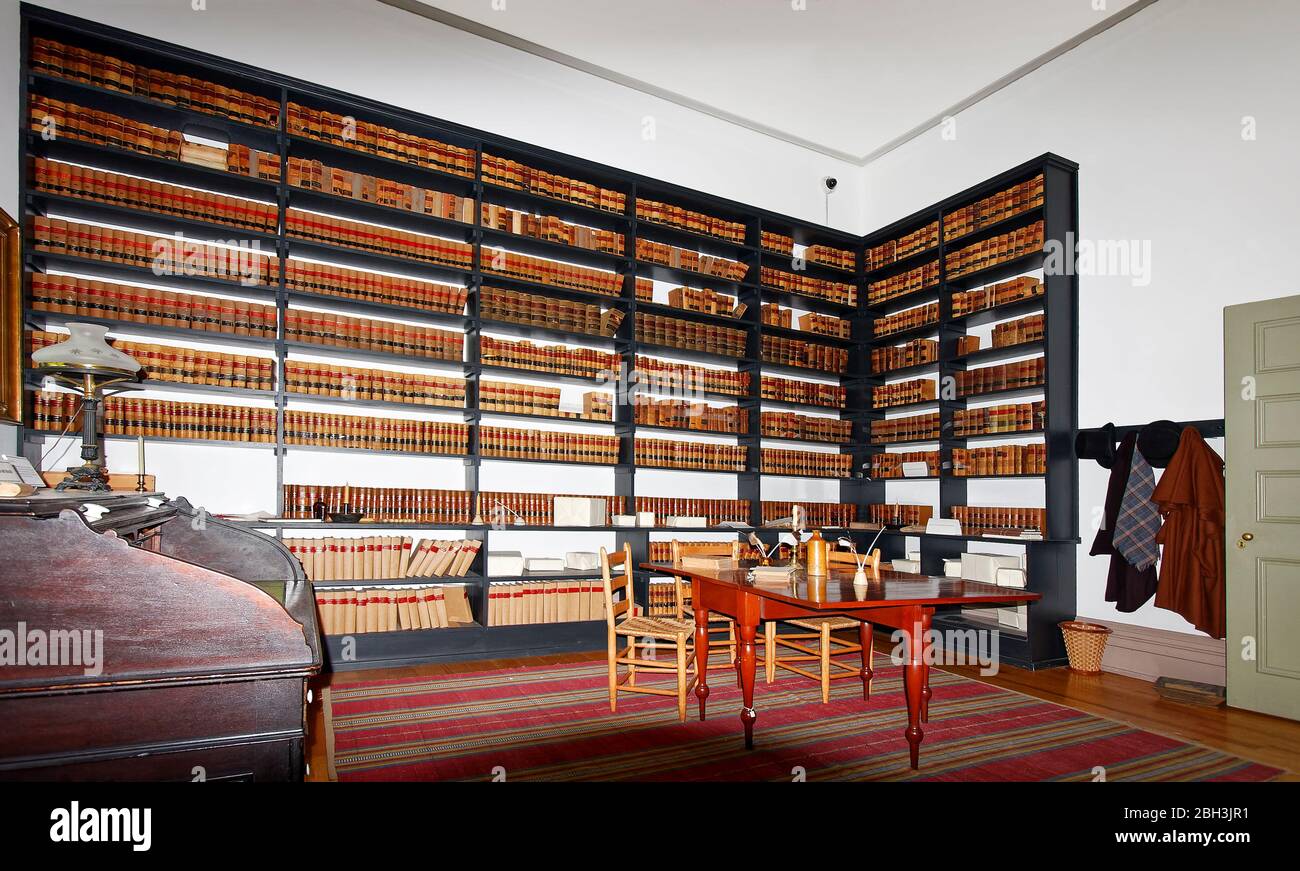 State Library, book shelves line walls, sofa, table, chairs, desk, rug ...