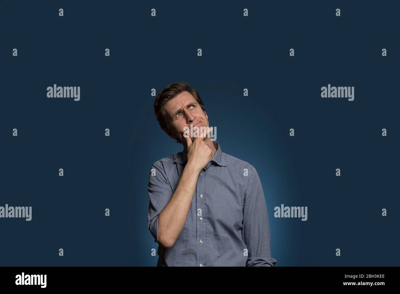 Man with Hand on Chin and Thinking Facial Expression Stock Photo - Alamy