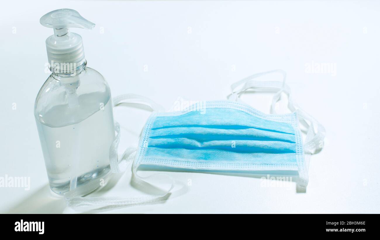 Close up view of plastic bottle with alcohol gel, blue face mask on ...