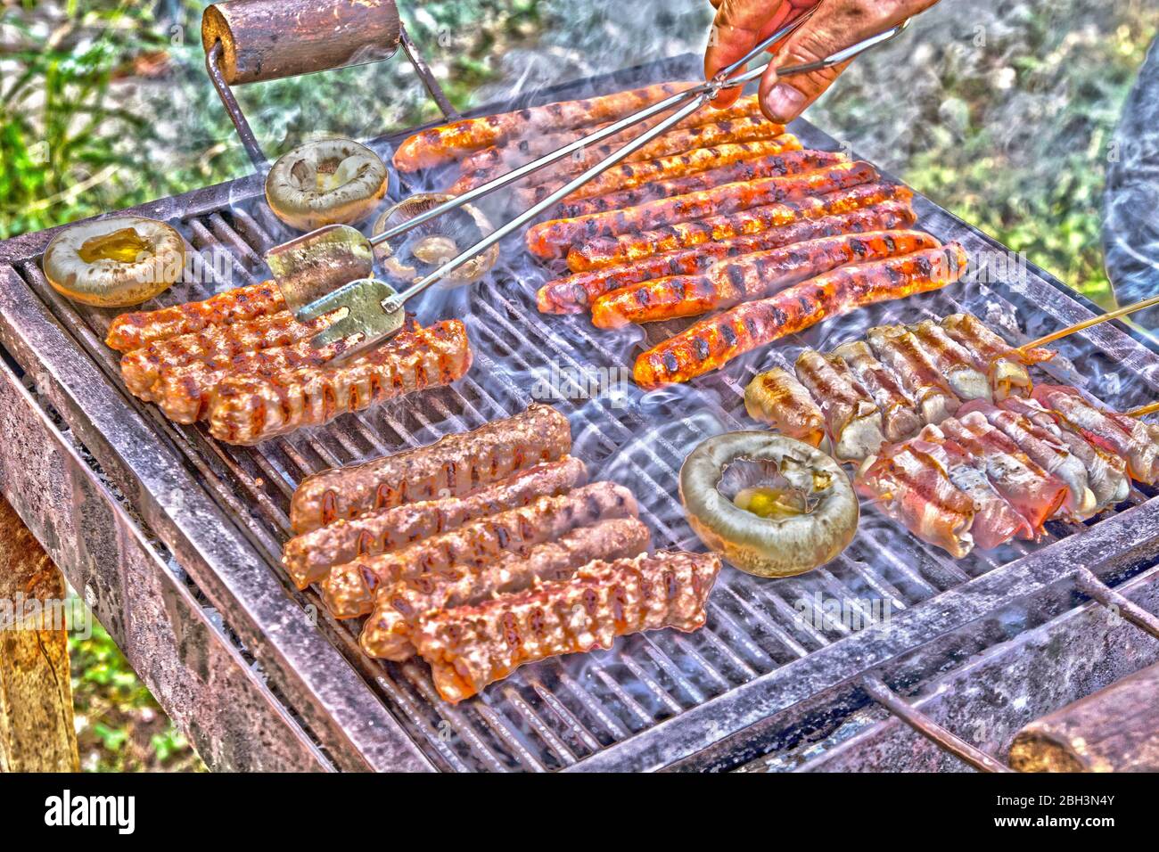Preparing barbecue meat at picnic in nature. The meat is roasted in a ...